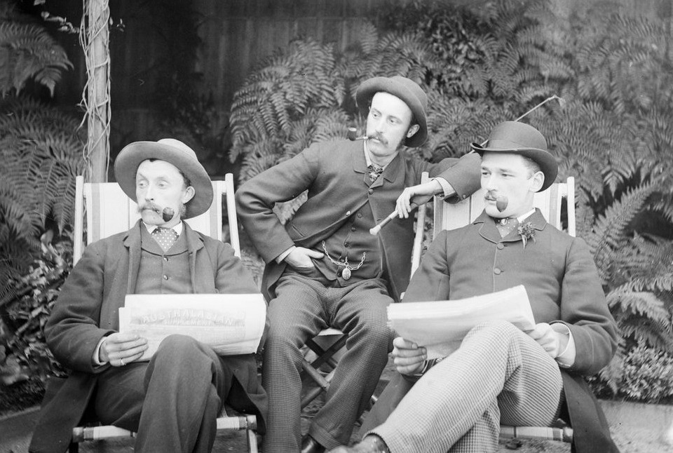 Three Men Together – smoking pipes, wearing hats, and proudly ...